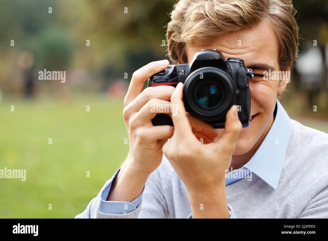 Finding the perfect subject matter. Shot of a young man taking photos ...