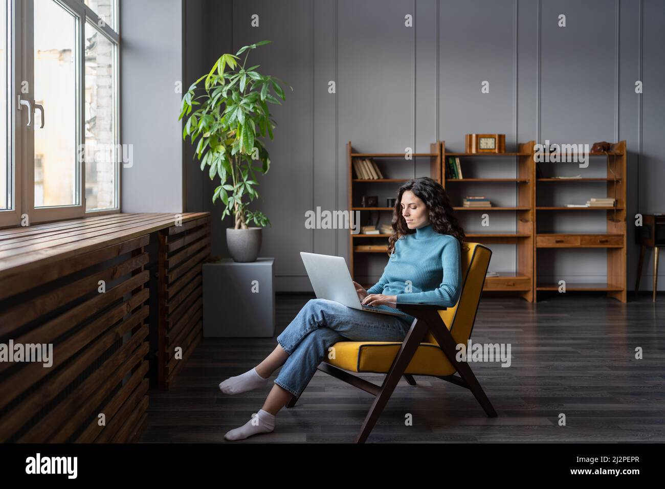 Young woman freelancer work on laptop at home typing email to client or ...