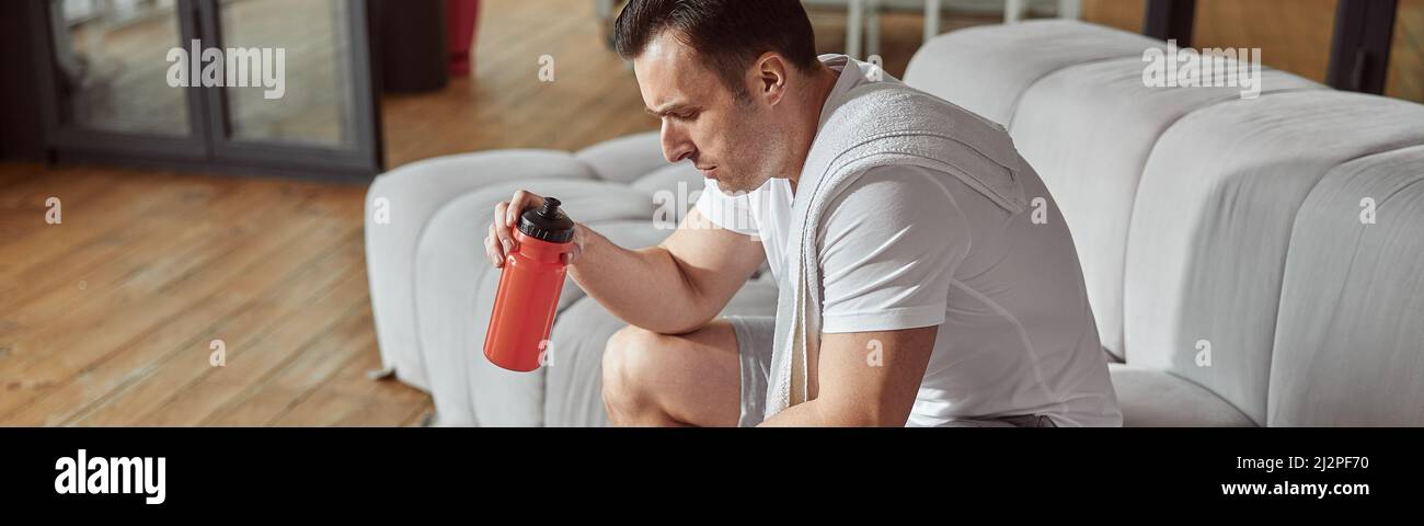 Athletic male drinking water after training indoor Stock Photo - Alamy