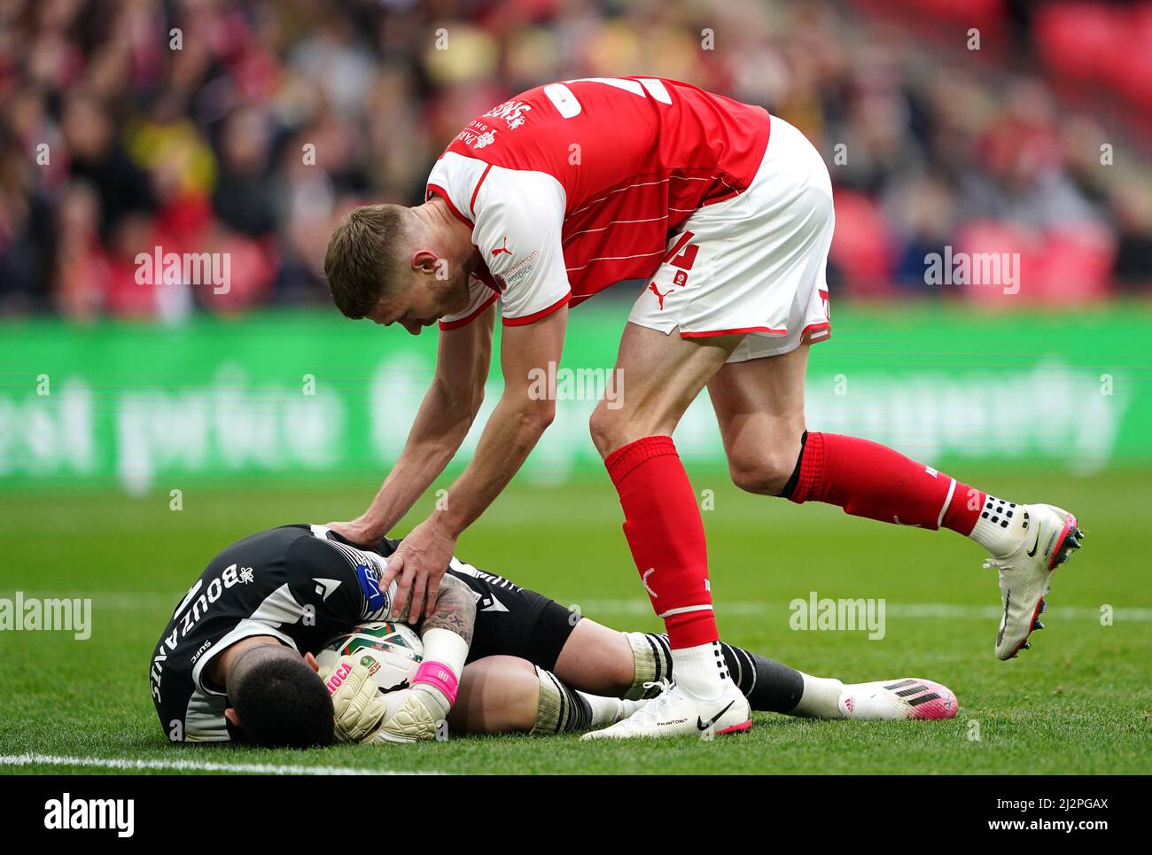 Rotherham United's Michael Smith (right) helps up Sutton United ...
