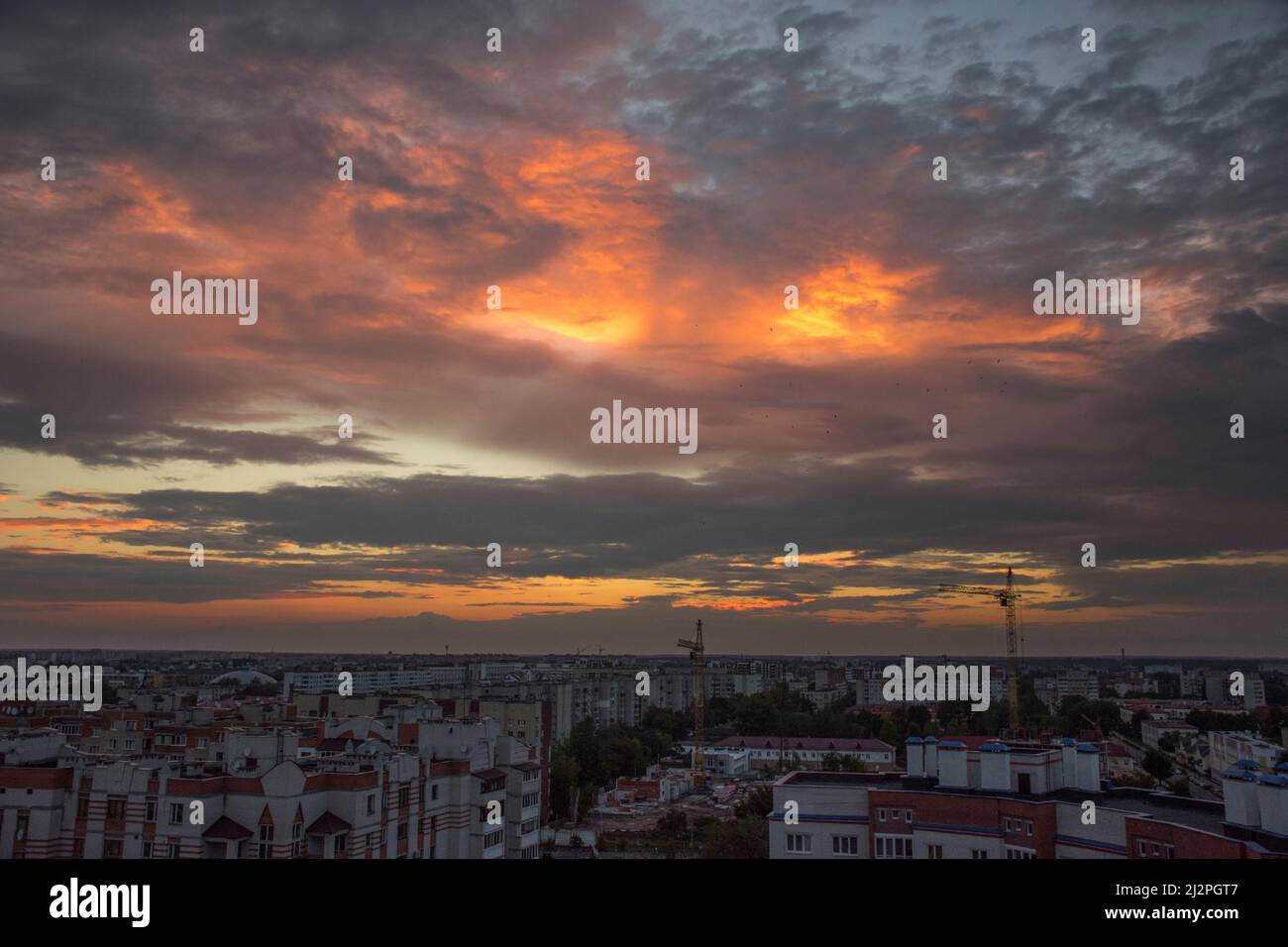 colorful sunset over city roofs Stock Photo - Alamy
