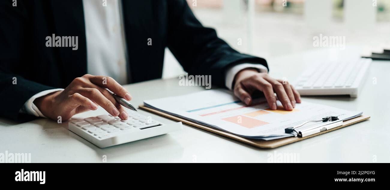 Close up accountant working on desk using calculator for calculate ...