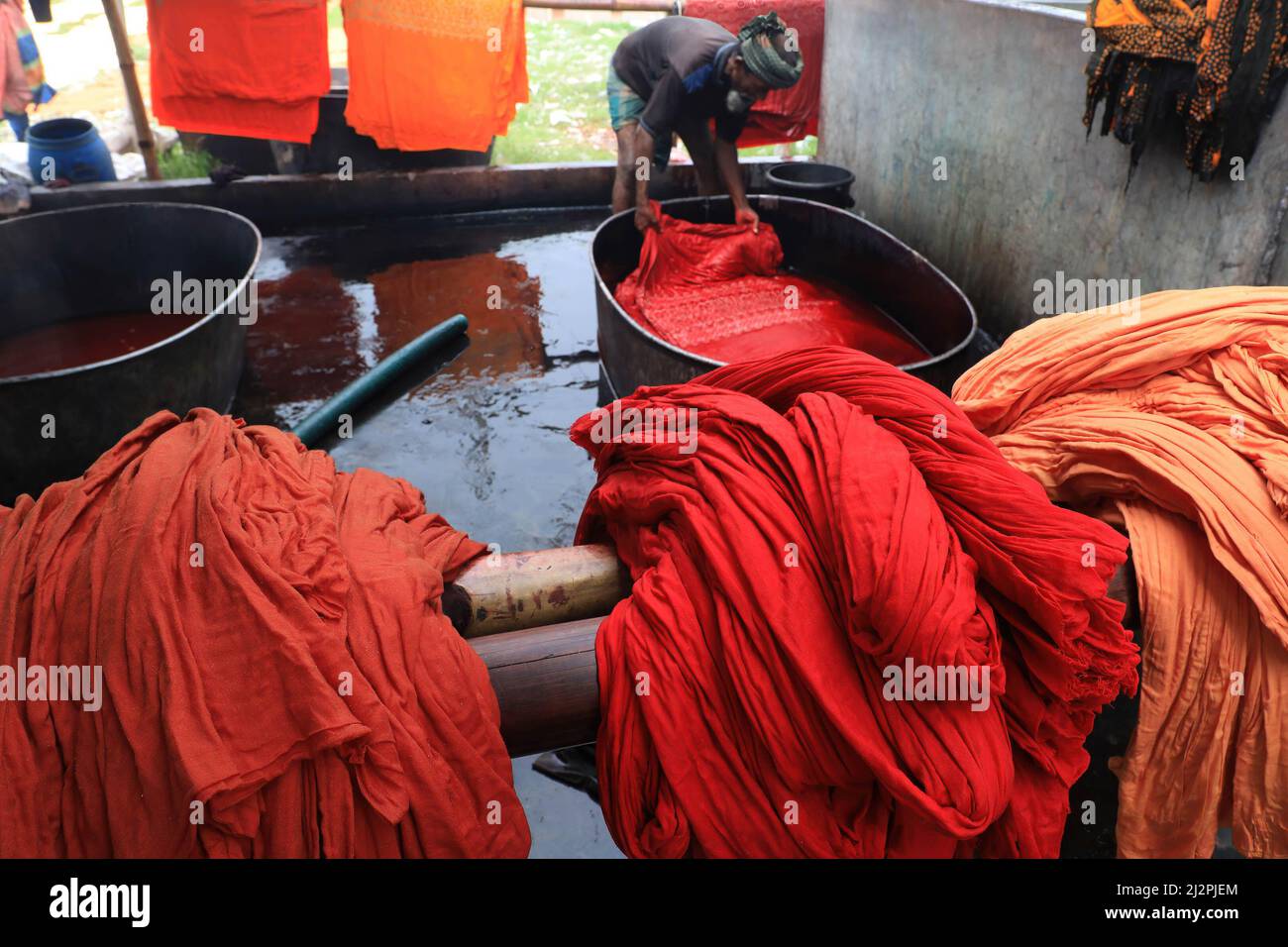 Narayanganj, Bangladesh. 2nd Apr, 2022. A man seen applying colour to the fabrics at the dye ...
