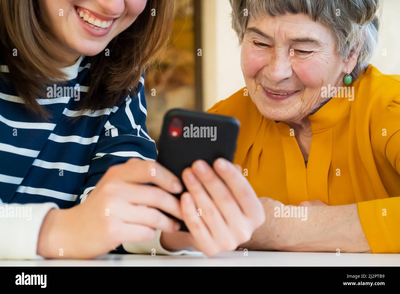 Girl helps her grandmother with mobile phone Stock Photo - Alamy