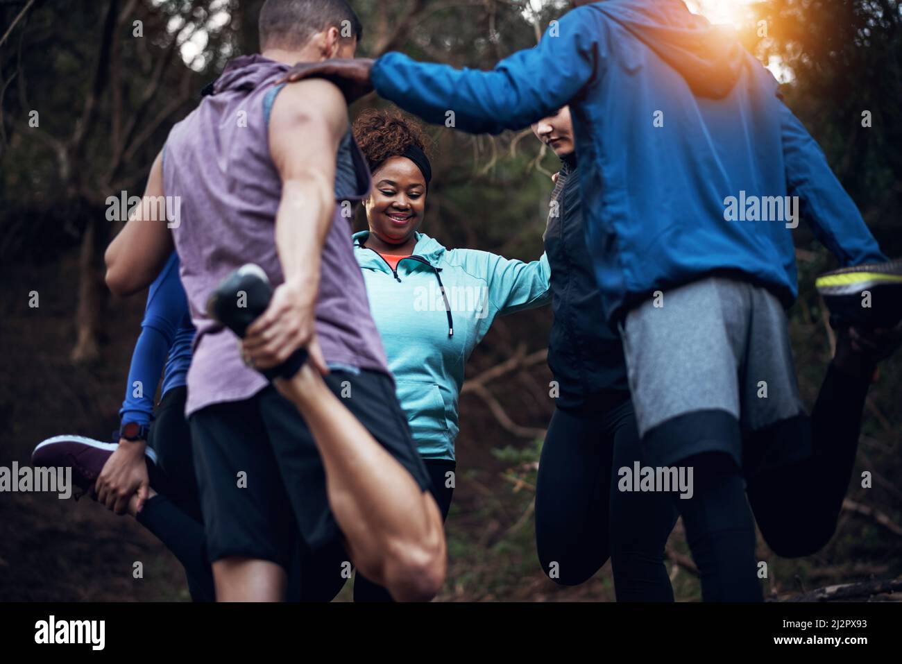 Stretching together and helping one another. Cropped shot of a sporty ...