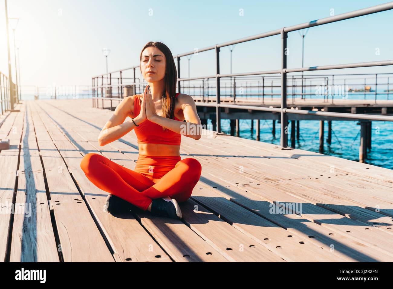 Woman relaxing in yoga position in the summer in front of the sea Stock ...