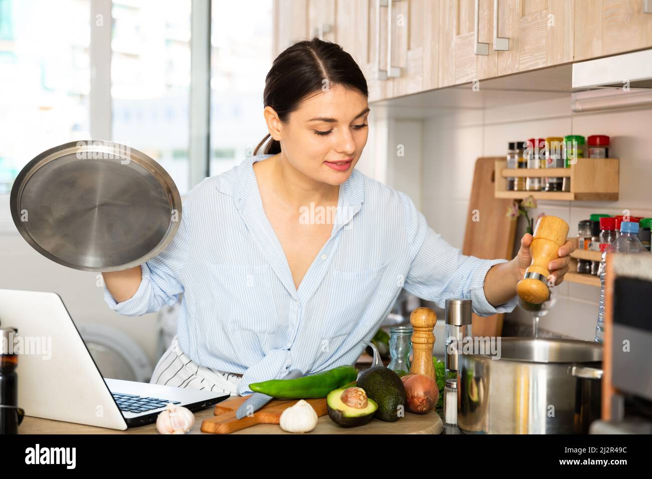 Nice woman planning to cook, looking for recipe on internet in her ...