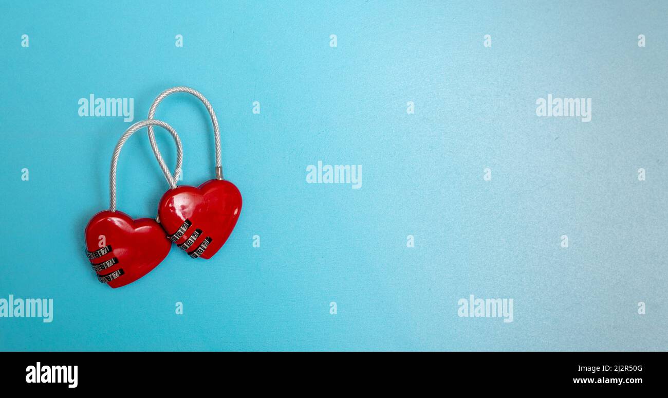 Two clasp hearts connected together on a blue background. The concept ...