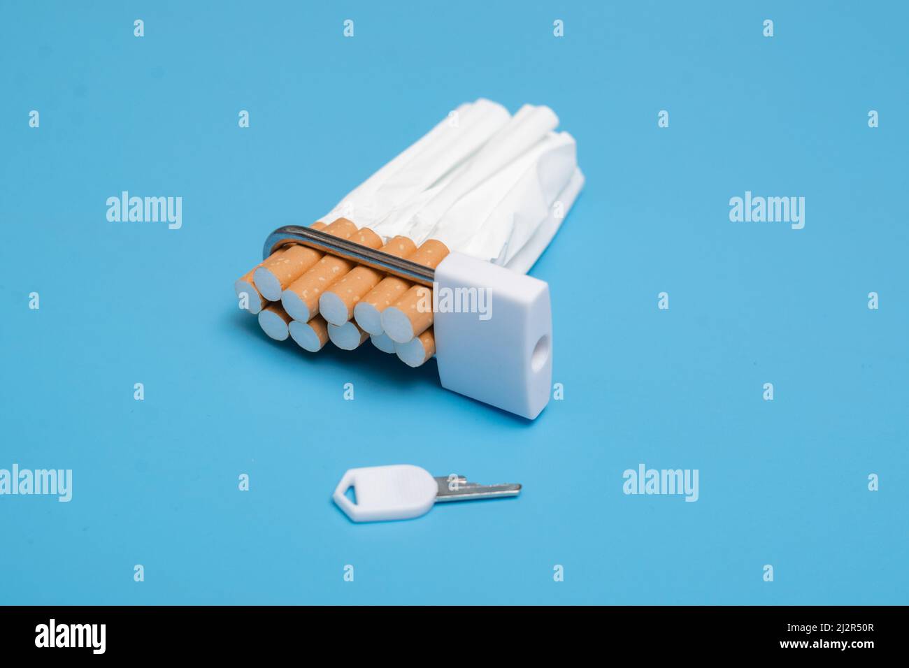 Quit smoking concept. Cigarettes squeezed into a lock on a blue ...