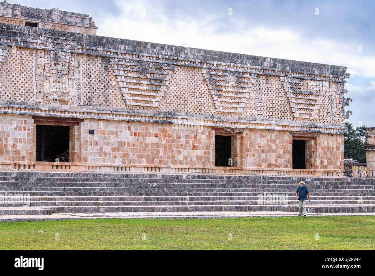 Mature man exploring ancient ruins of mayan Nunnery Quadrangle (West ...