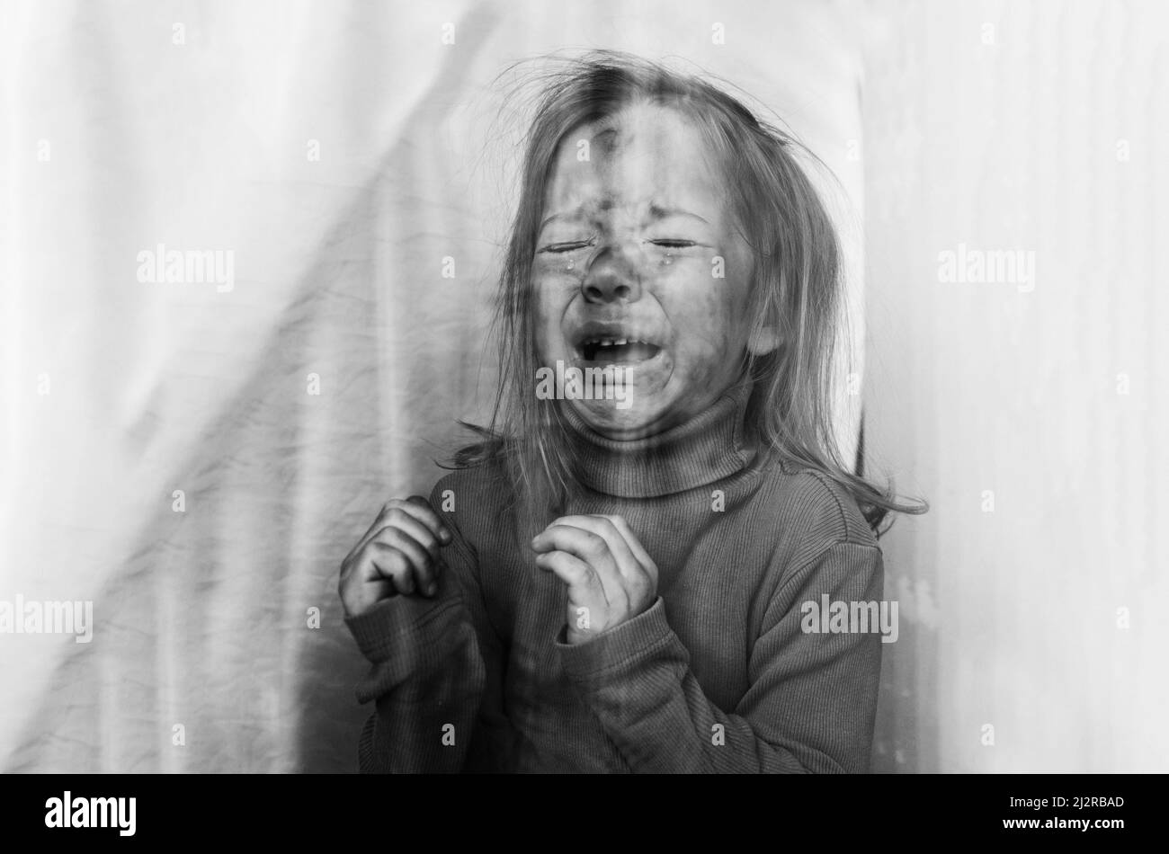 a little Ukrainian girl with a face blackened by fire is standing ...