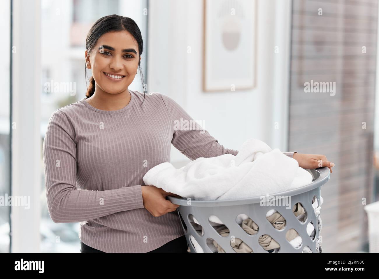 Laundry is actually infinite. Shot of a beautiful young woman doing the ...