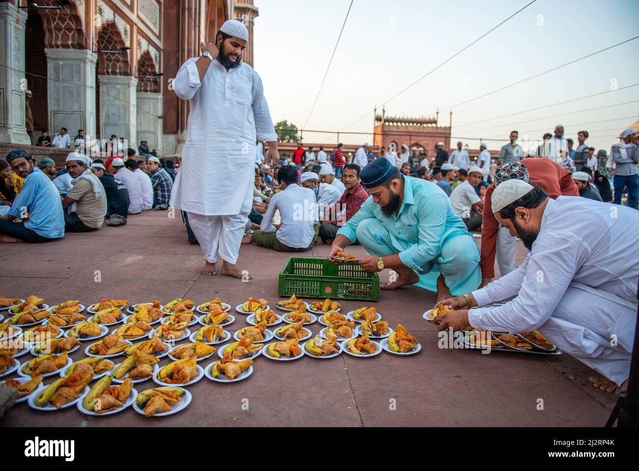 A Muslim volunteer prepares plates with snacks to be distributed to ...