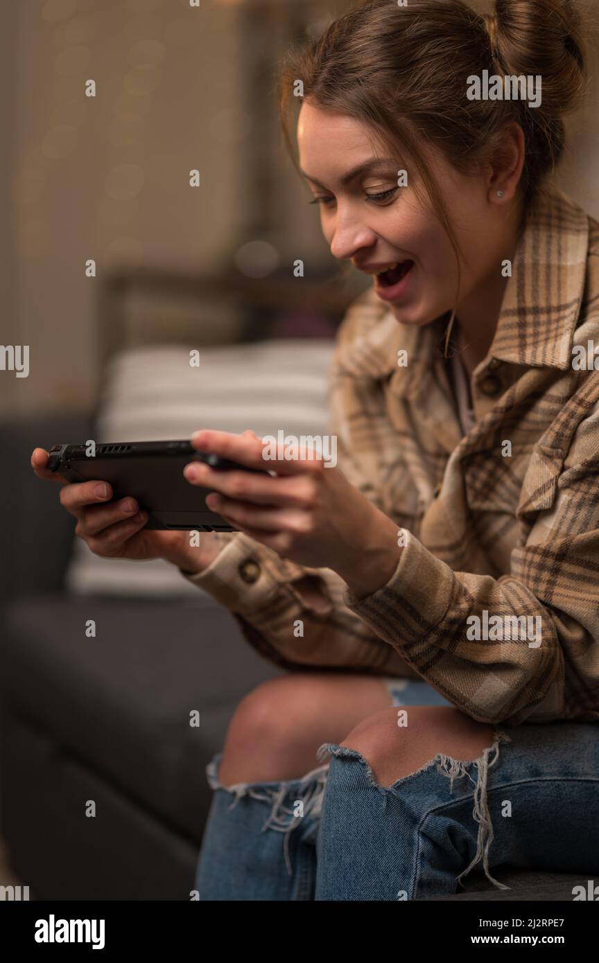A girl gamer or streamer enthusiastically plays a video game on a ...