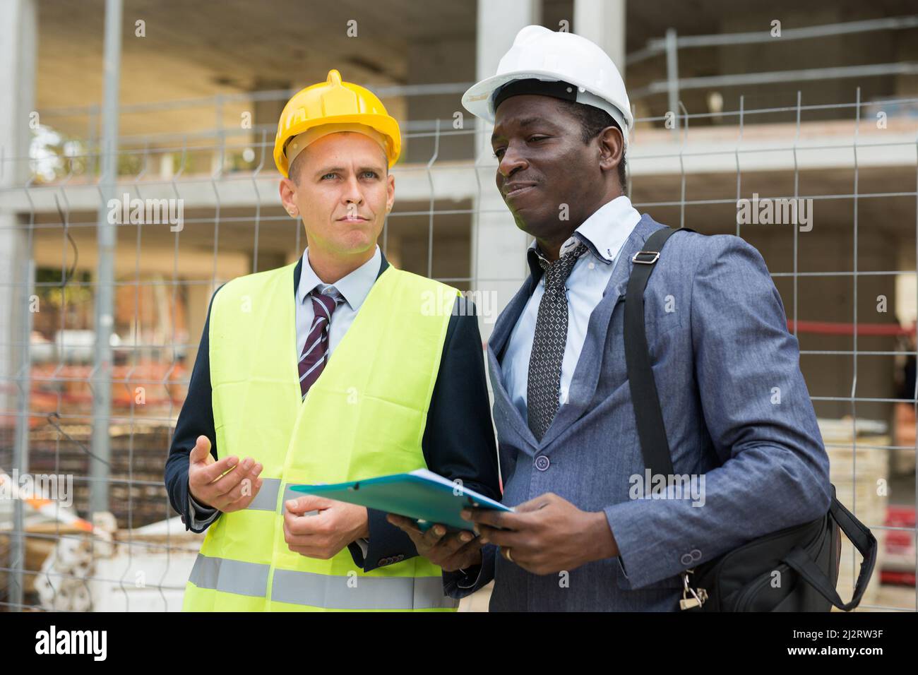 African-american architect discusses a construction plan with an ...