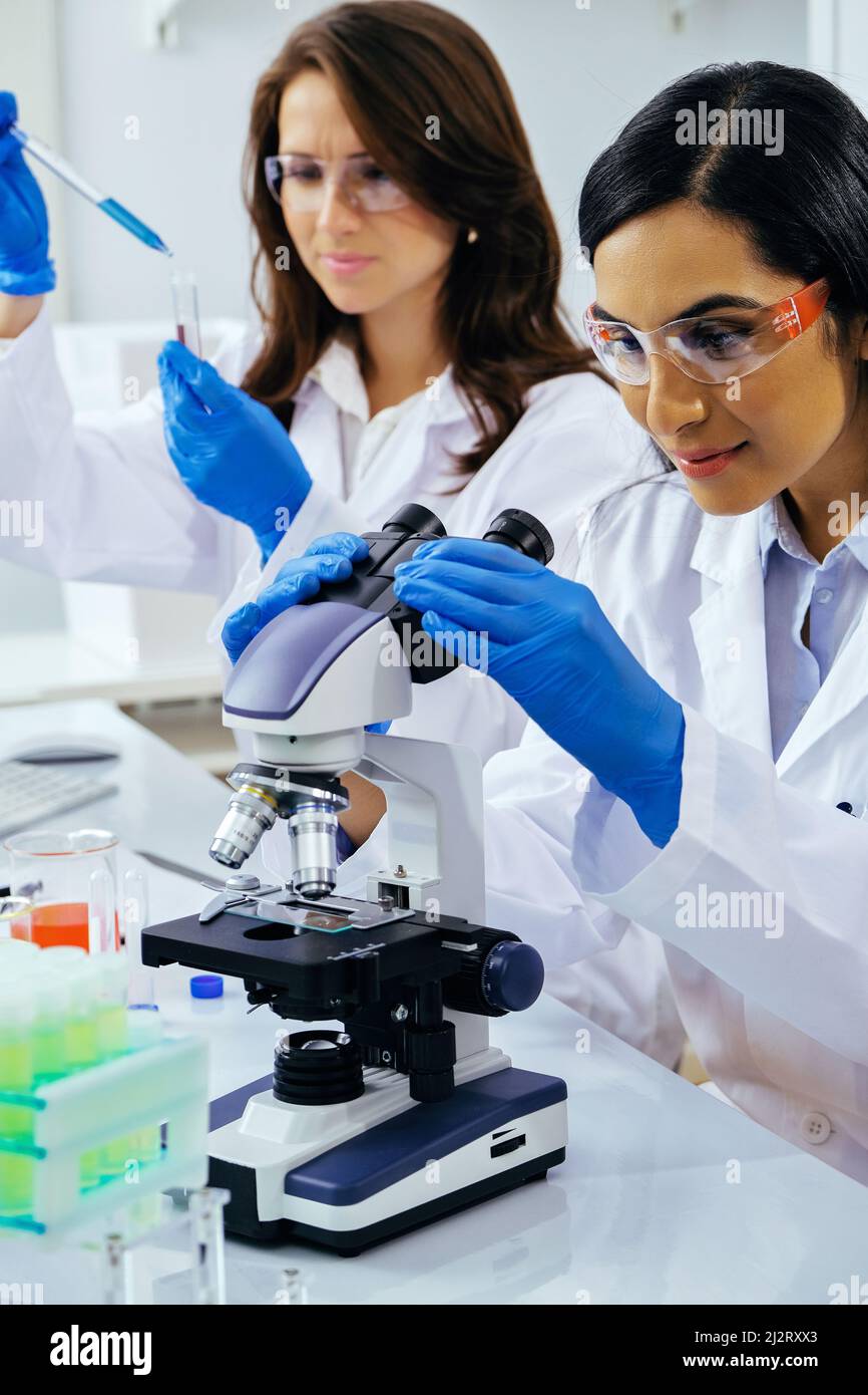 Two beautiful young female scientists working in laboratory with test ...