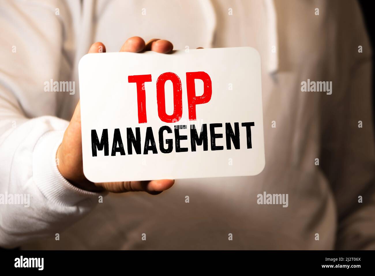 Businessman shows a card with word Top Management. CEO position ...