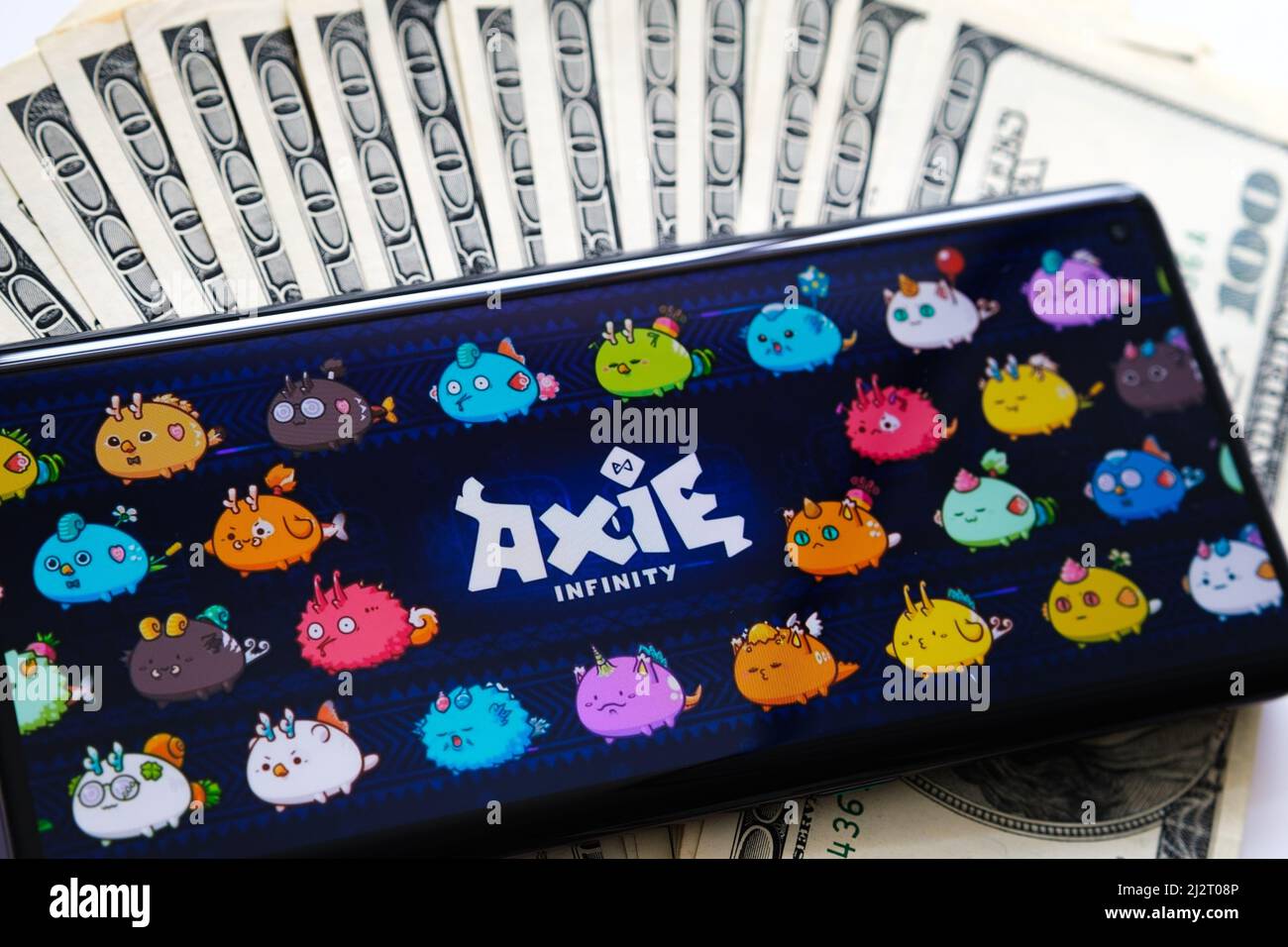 Axie infinity NFT game logo seen on the screen of smartphone and dollar ...