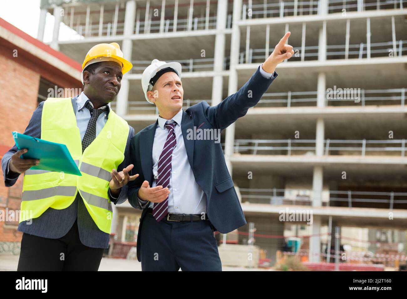 Two architect, civil engineer or building contractor colleagues on ...