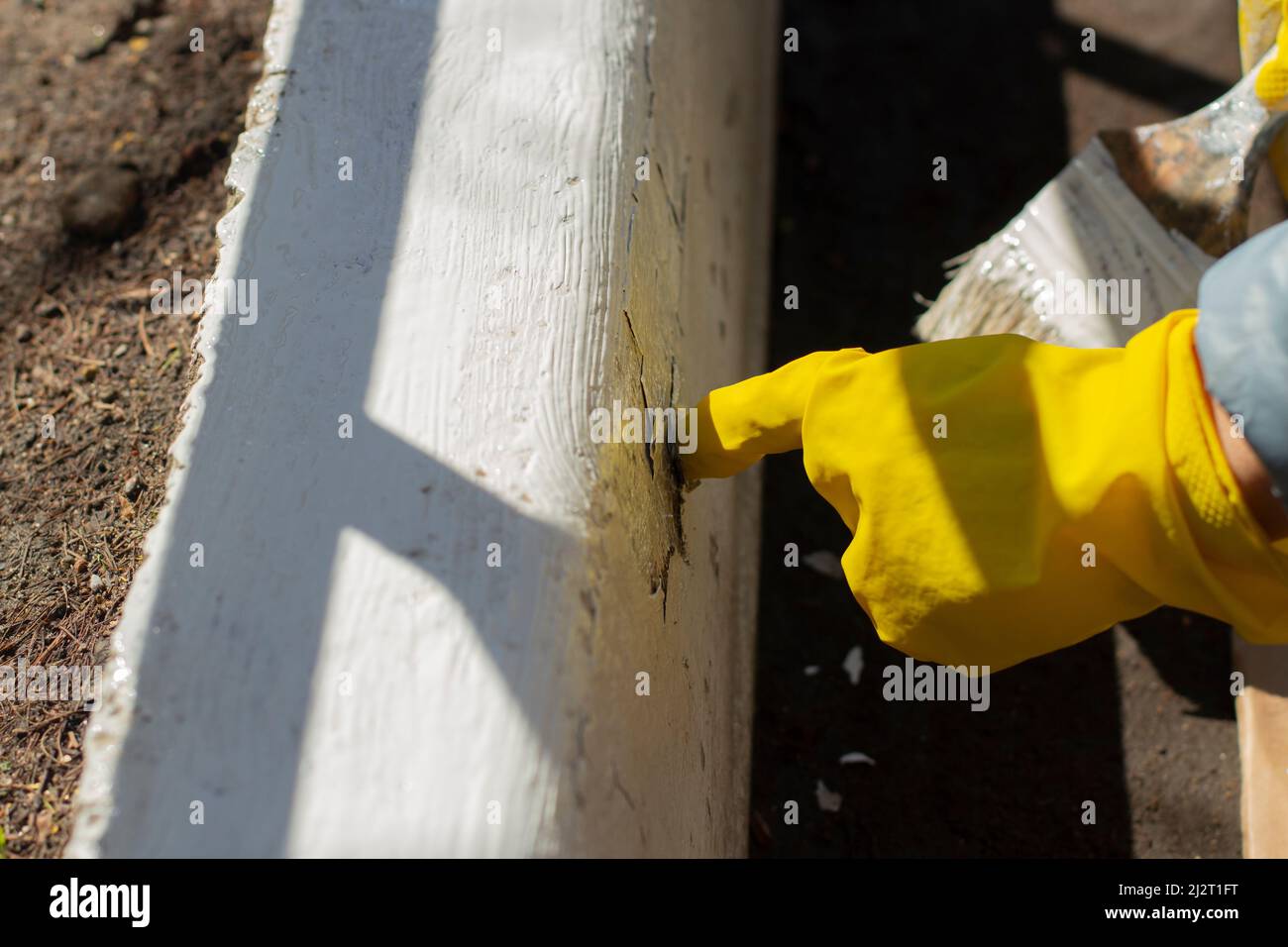 Painting borders with white paint. Applying oil paint to asphalt ...