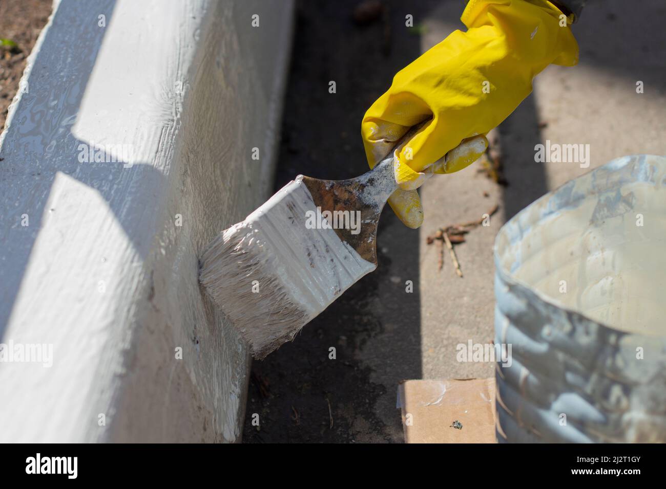 Painting borders with white paint. Applying oil paint to asphalt ...