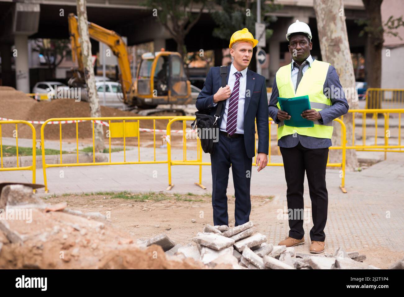 Architect tells engineer where to dig a trench to lay pipe Stock Photo ...