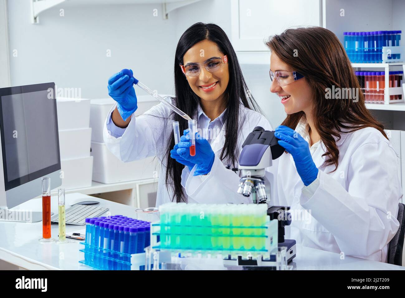 Two beautiful young female scientists working in laboratory with test ...