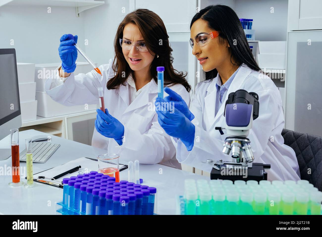 Two beautiful young female scientists working in laboratory with test ...