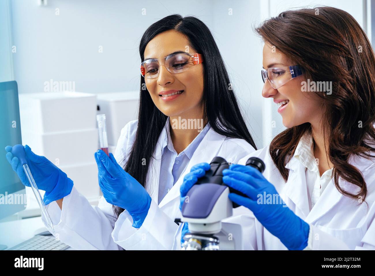 Two beautiful young female scientists working in laboratory with test ...