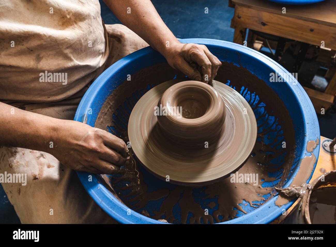 The skilled Hands of a potter working clay on a potter's wheel. The ...