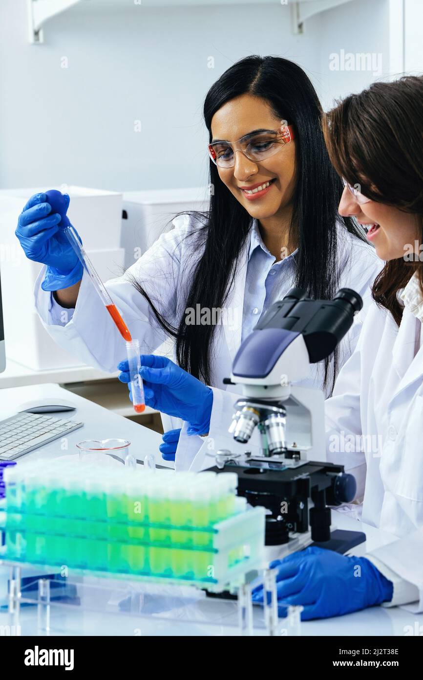 Two beautiful young female scientists working in laboratory with test ...