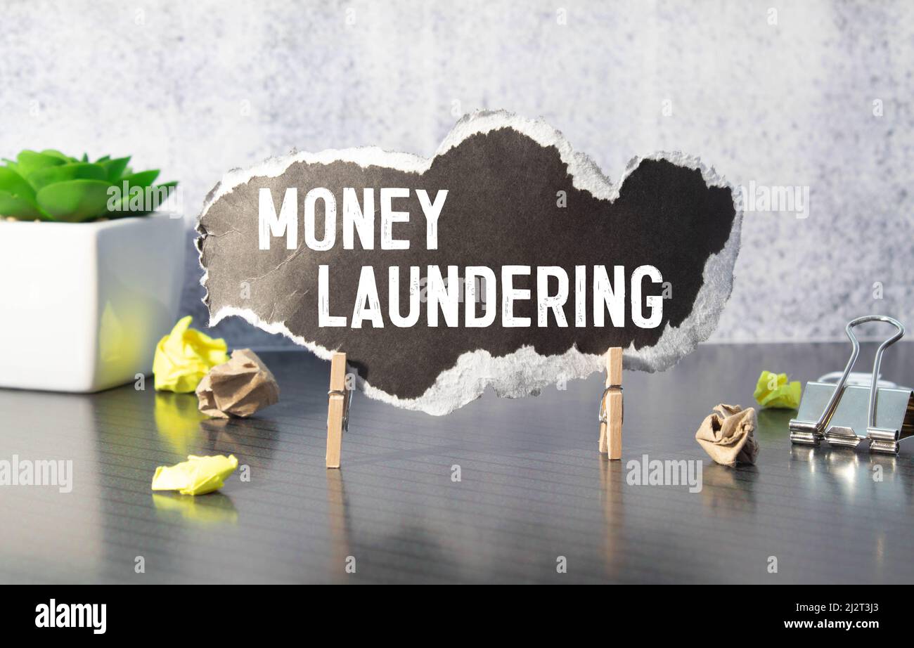 Hand underlining money laundering with red marker Stock Photo - Alamy