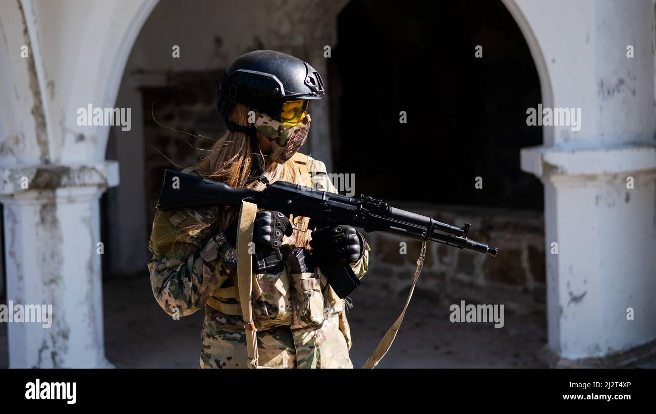 Caucasian woman in a protective suit with a machine gun. A female ...