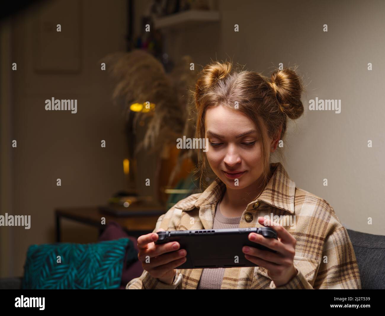 A cute girl with a portable game console plays a video game. Mobile ...