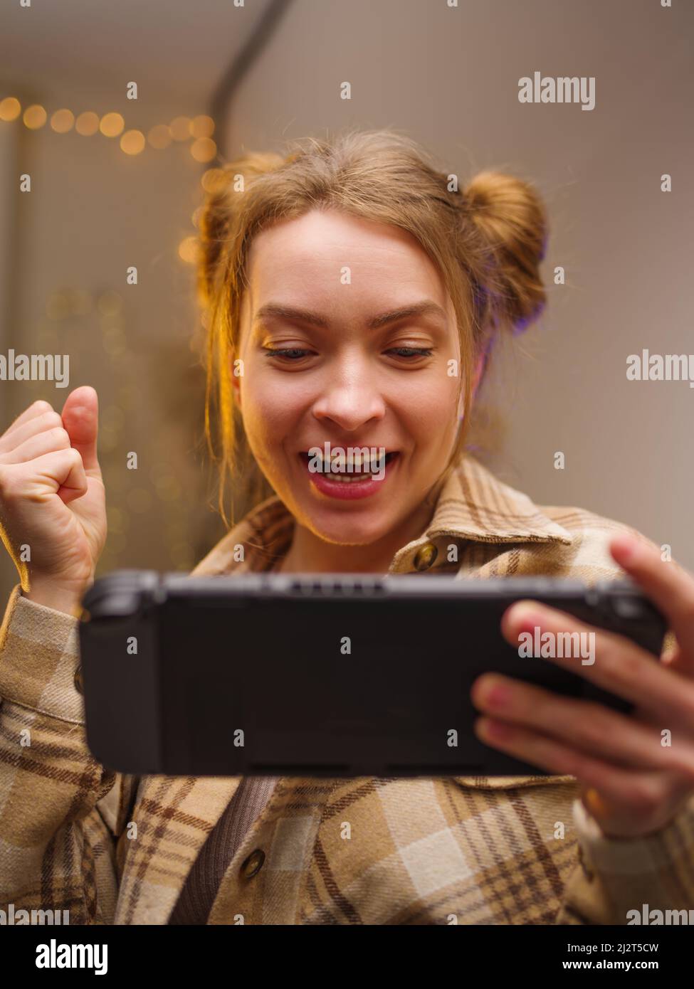 Joyful pretty girl with a portable game console. Online games with ...