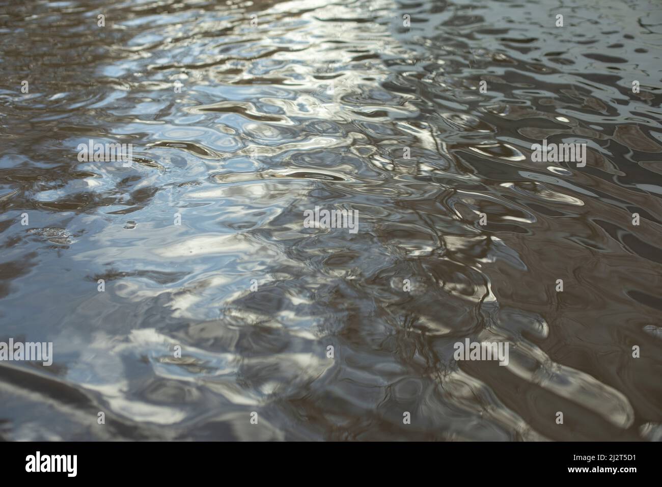 Texture of water. Surface of puddle. Small waves. Reflection in water ...