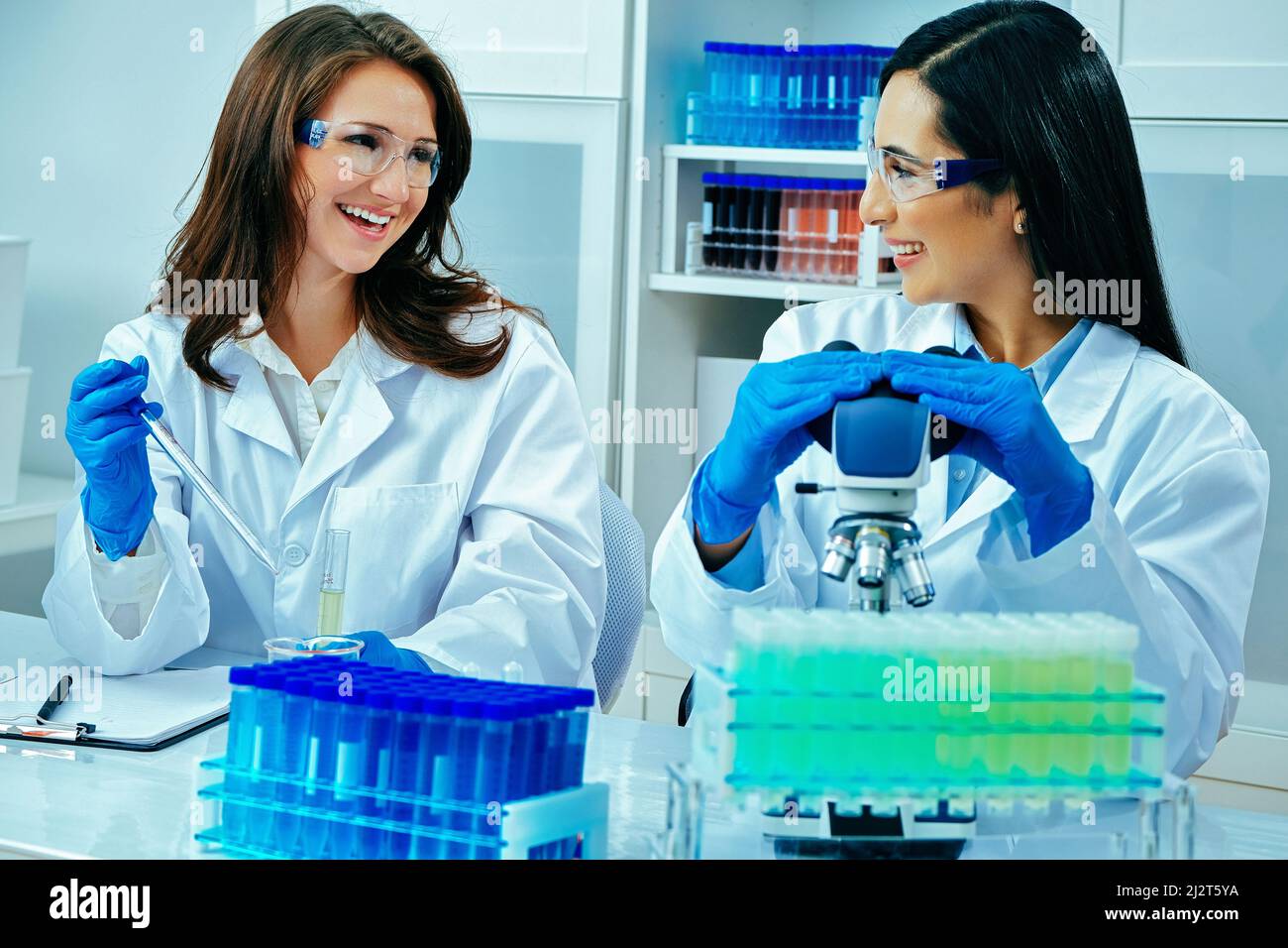 Two beautiful young female scientists working in laboratory with test ...