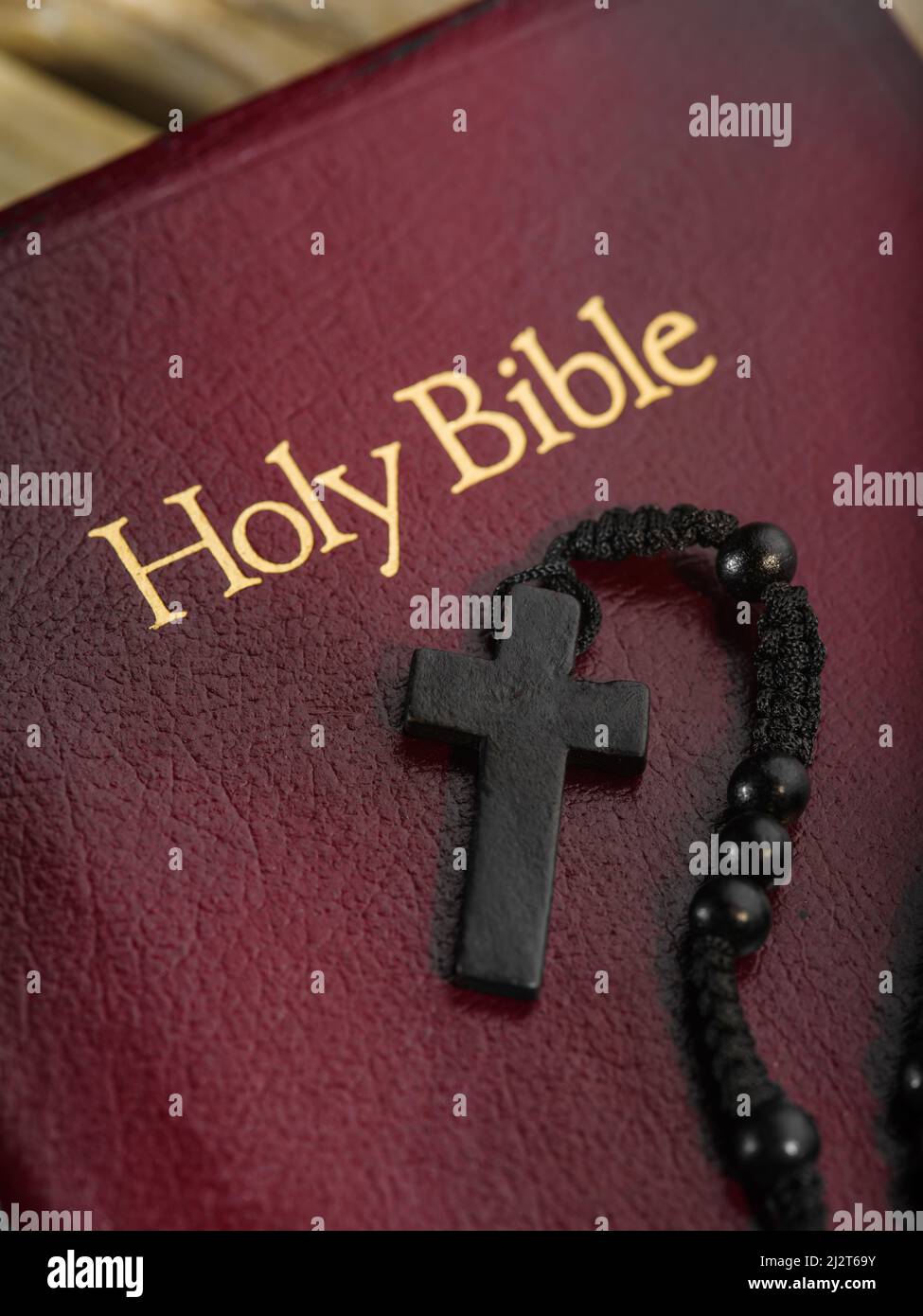 Catholic rosary and cross on the background of the red book - the Holy ...