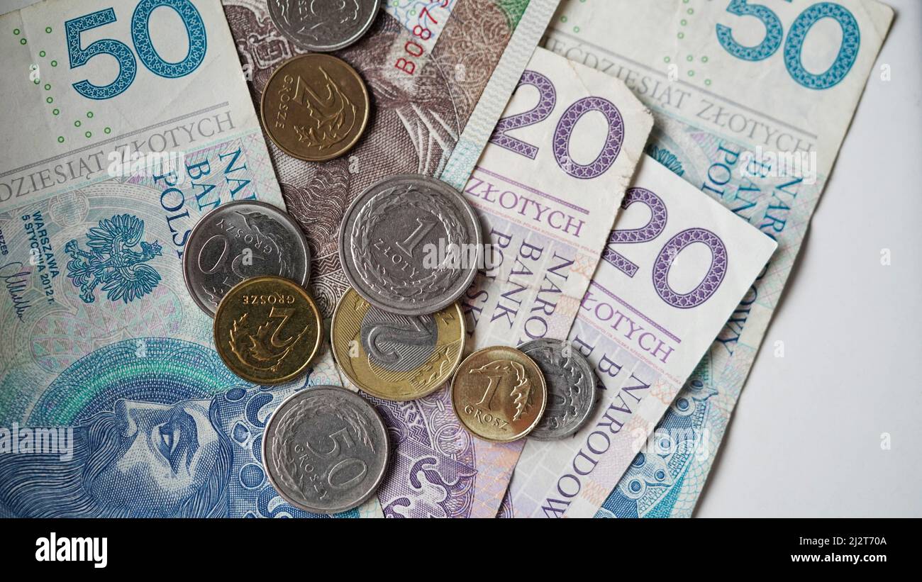Close-up of zloty banknotes and coins on a white background, Polish ...