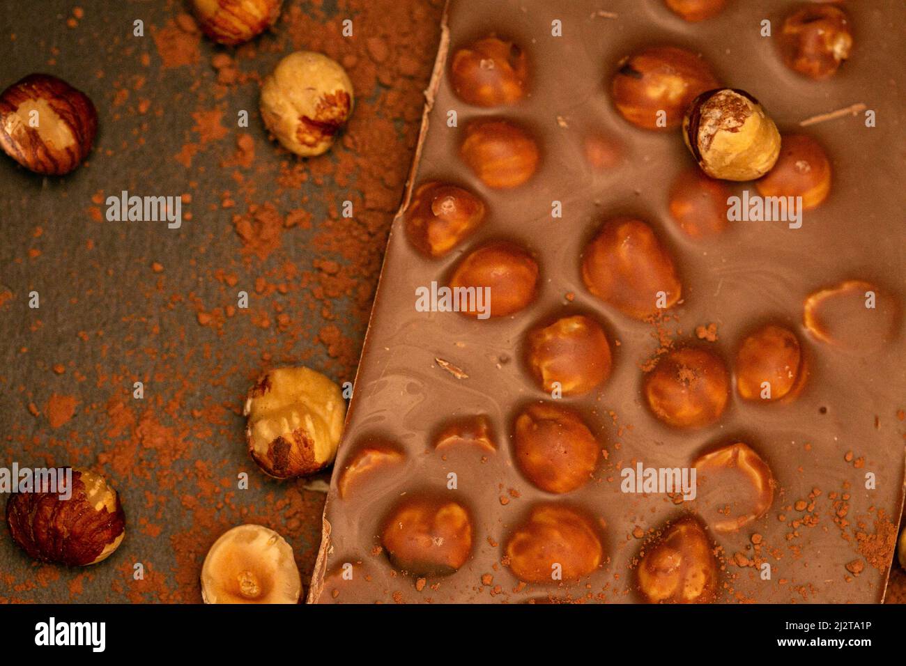 Chocolate with hazelnuts and cocoa powder on a slate background ...