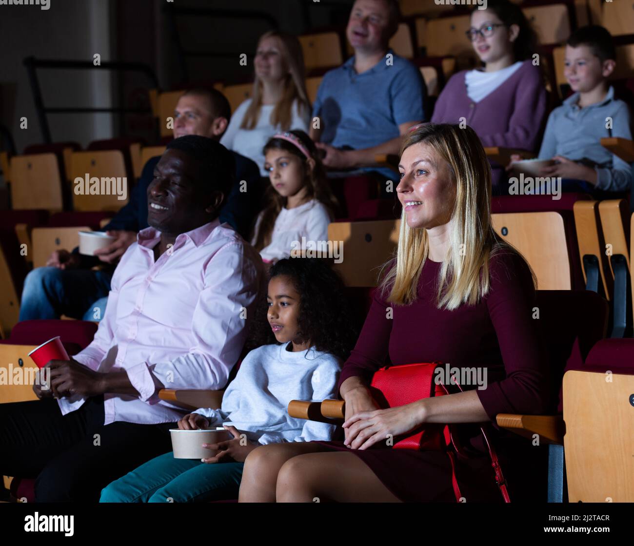 caucasian mother, african father and their children sitting at comedy ...