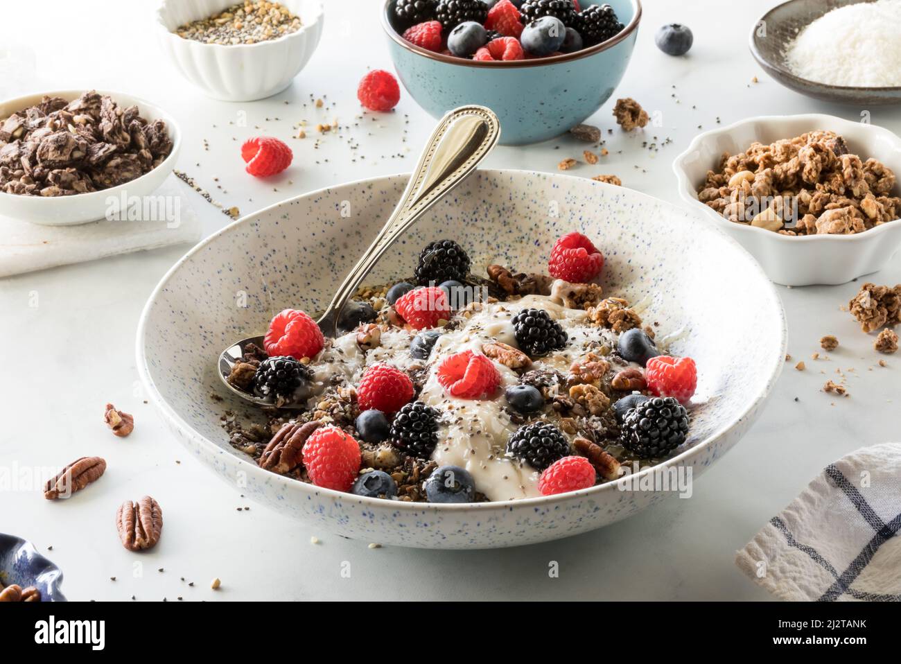 A look inside a bowl of oat yoghurt and toppings of berries, nuts and ...