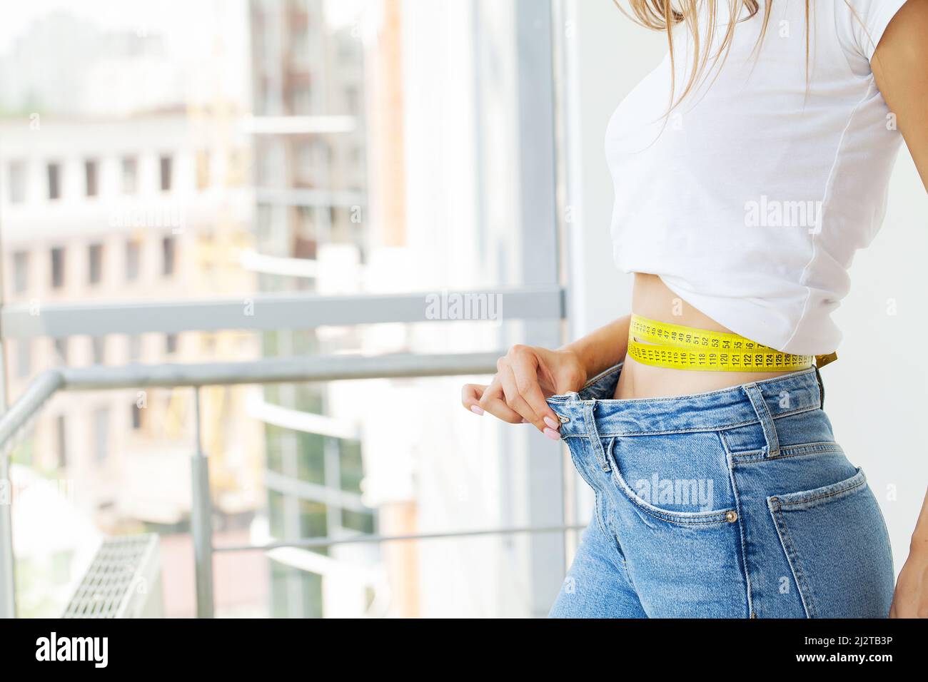 Slim young woman measuring her thin waist with a tape measure Stock ...