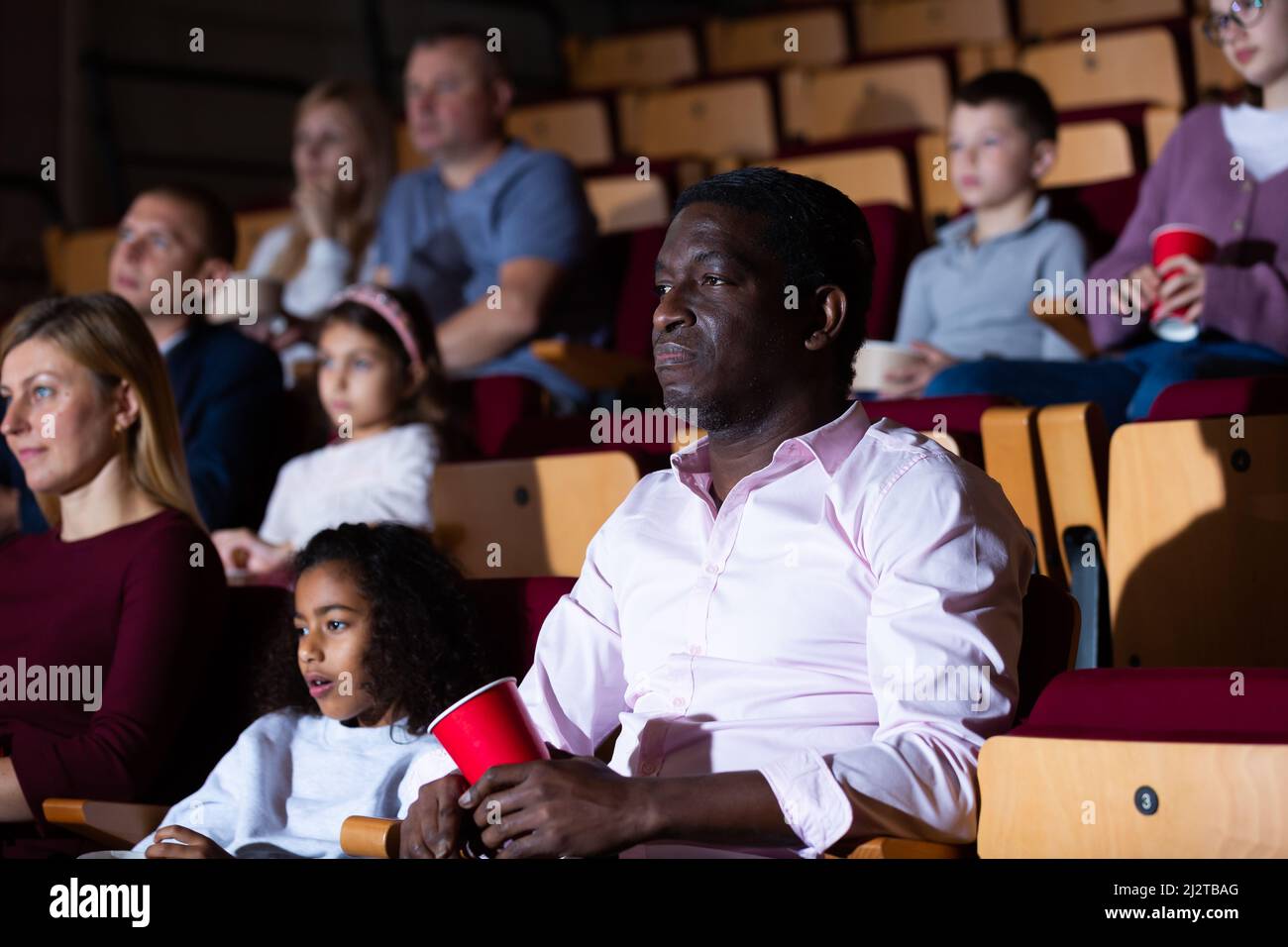 African american man with family watching film in movie theater Stock Photo - Alamy