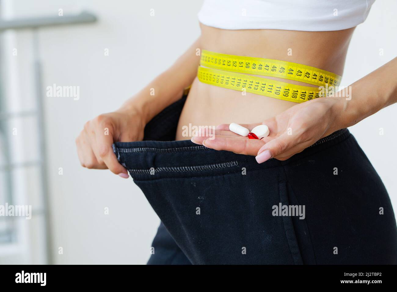Slim young woman measuring her thin waist with a tape measure Stock ...