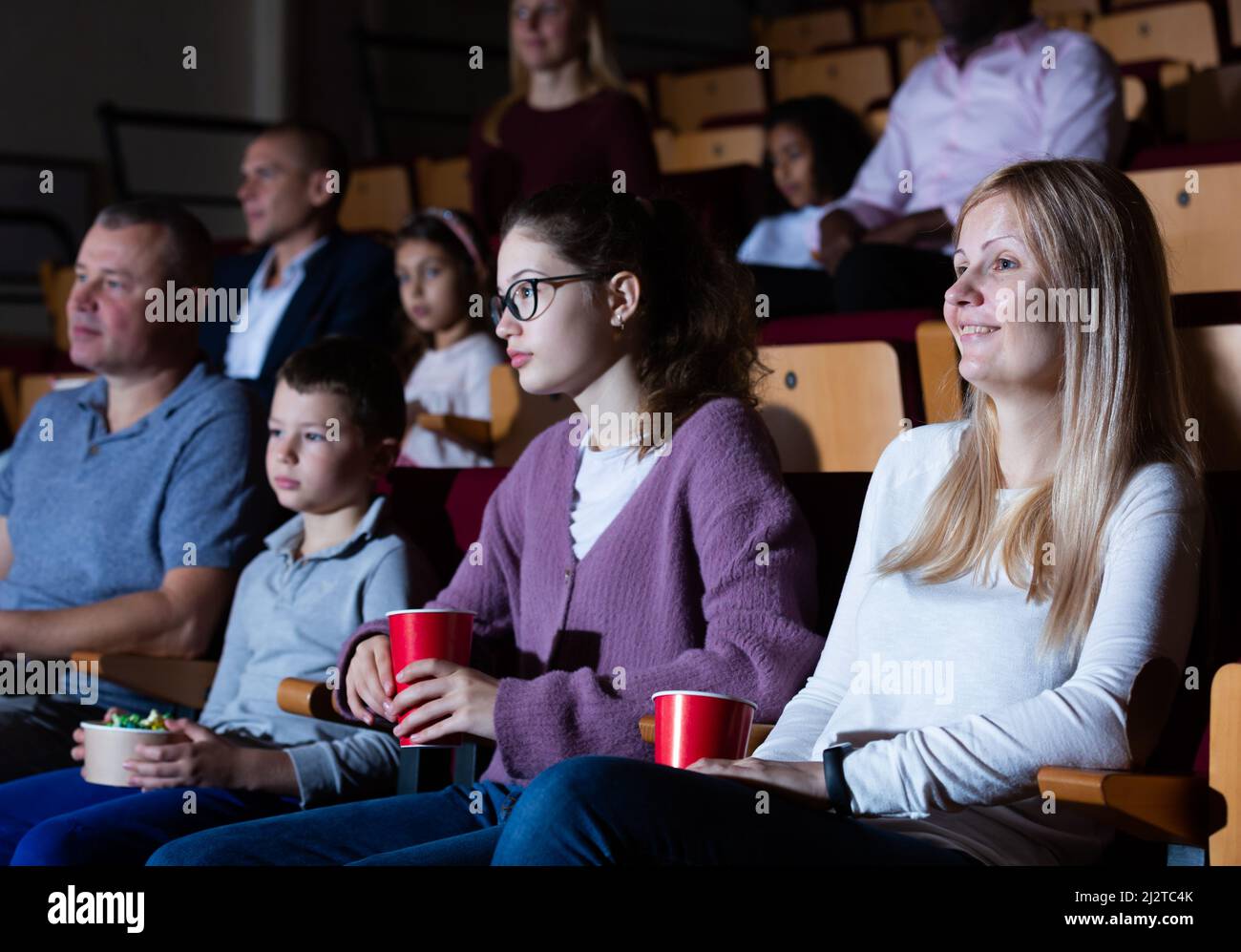 Spectators eating popcorn and watching movie at the cinema Stock Photo ...