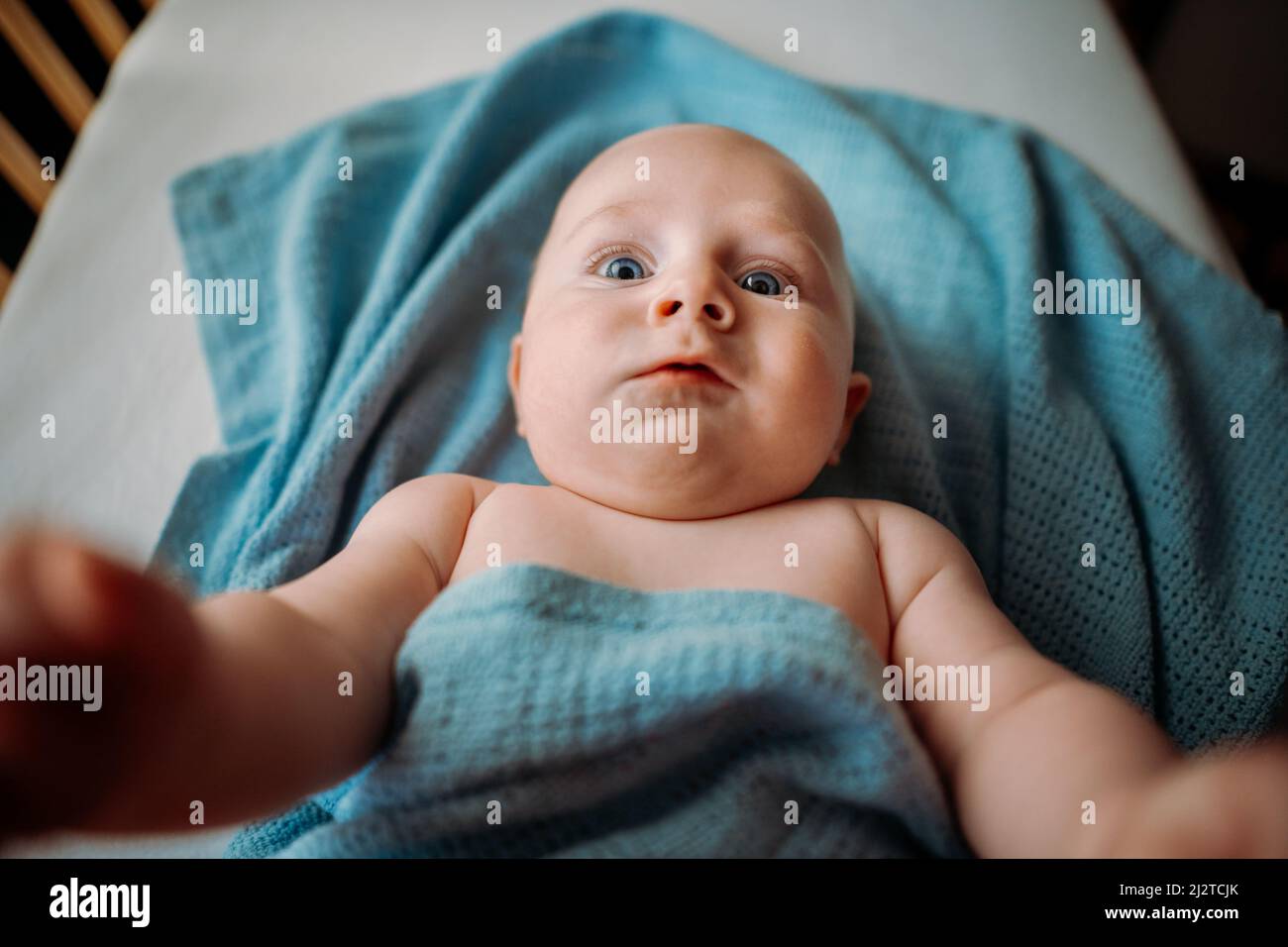 Baby toddler taking a selfie in crib. Holding smartphone. Scared face ...