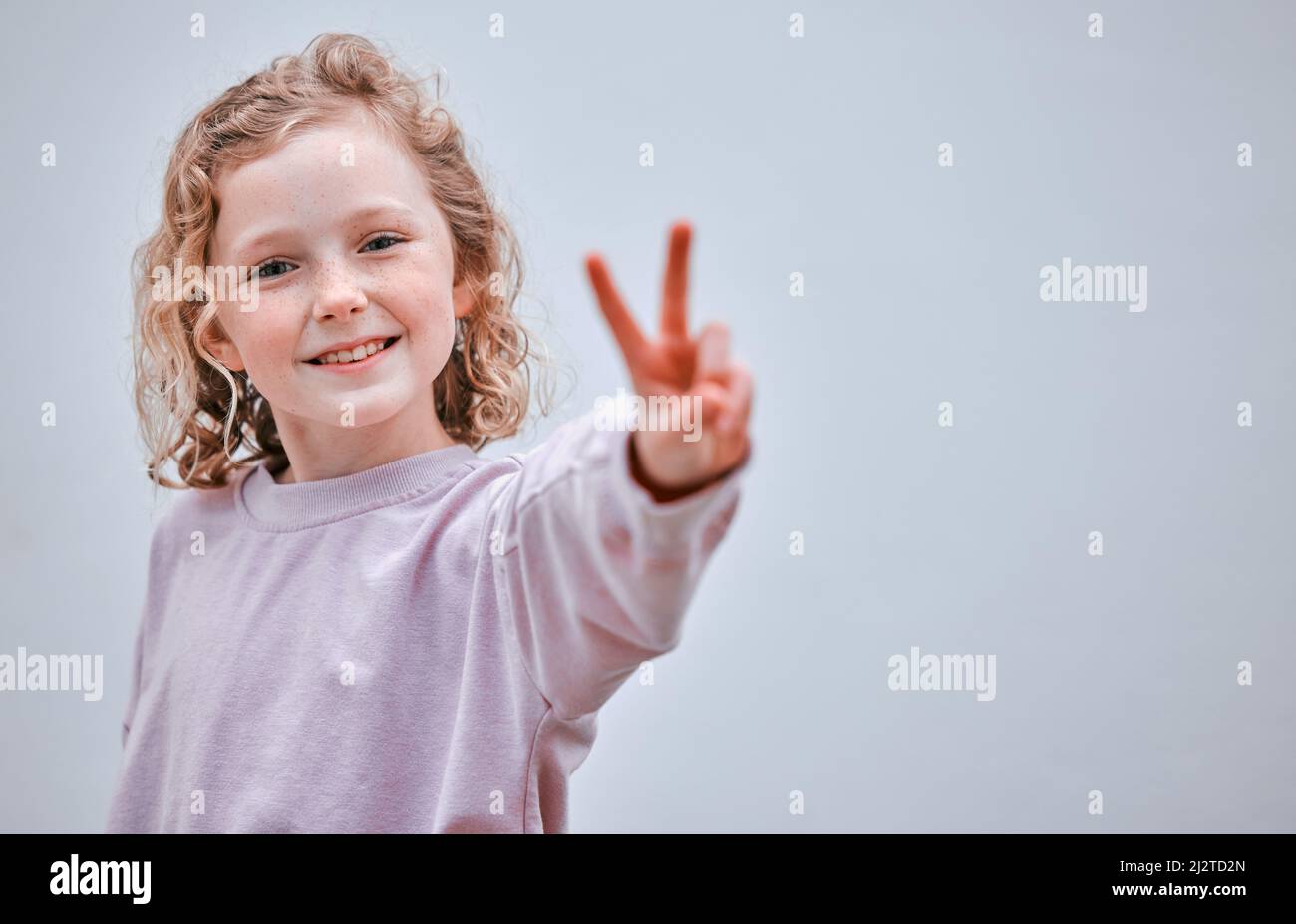 A confident kid is a happy kid. Studio shot of a little girl making a ...