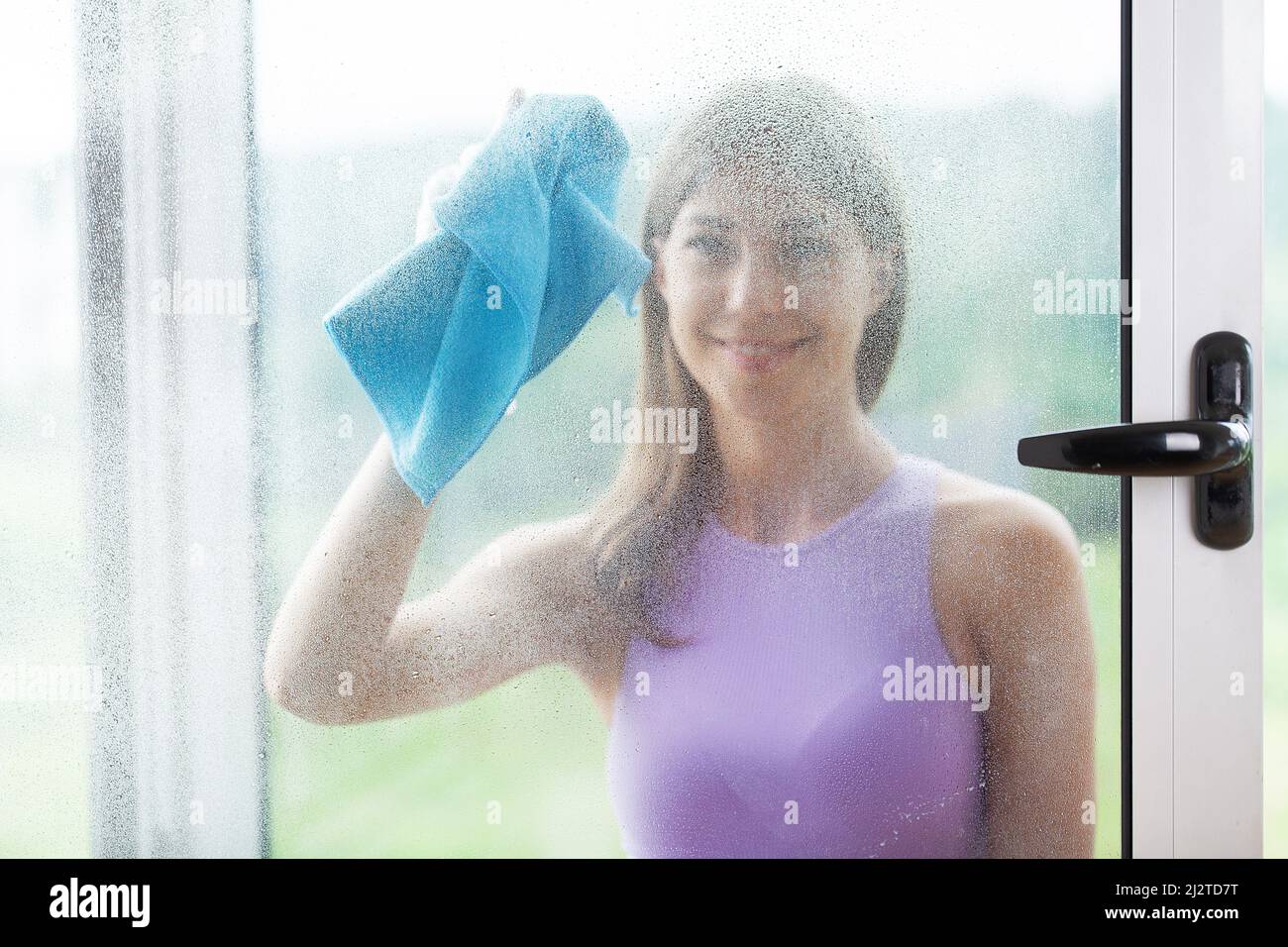 Happy young woman housewife washes a window Stock Photo - Alamy