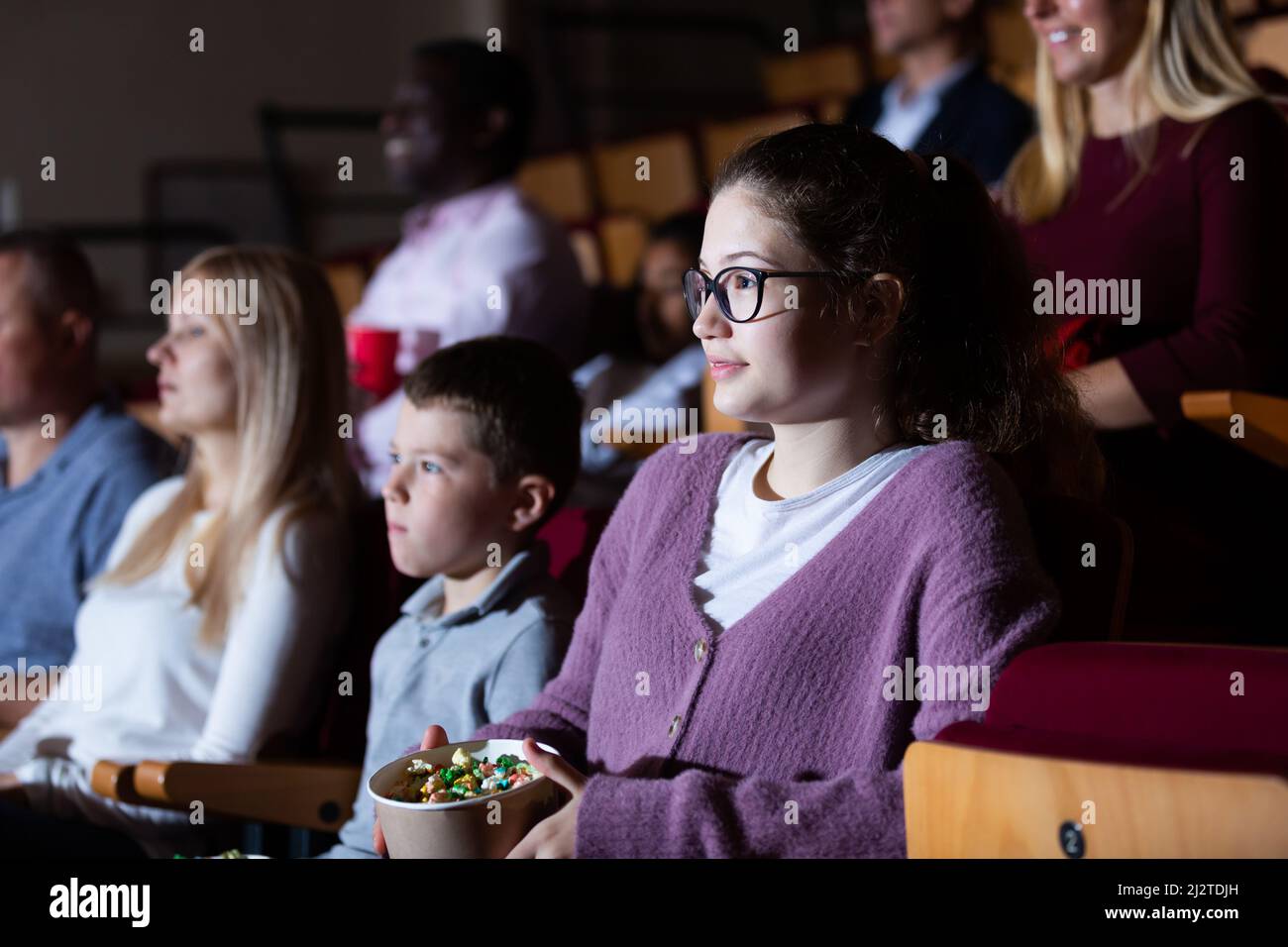Spectators eating popcorn and watching a movie at cinema Stock Photo ...